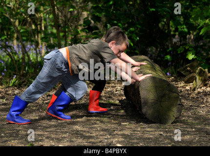 A boy and girl trying to roll a log Stock Photo - Alamy