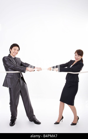 two smiling businesswomen pulling rope Stock Photo - Alamy