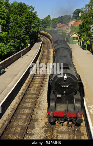 Historic steam train (loco) coming round bend in track, puffing smoke ...