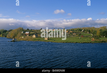 A small dacha farm in a riverside village under a stormy autumn sky ...