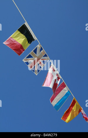 old faded international flags flying in wind in sun Stock Photo - Alamy