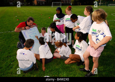 FA coach instructing primary school children i soccer skills and ...