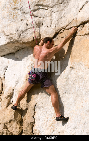 Climber scaling limestone rock-face, near Angles sur l'Anglin, Vienne ...
