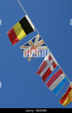 old faded international flags flying in wind in sun Stock Photo - Alamy
