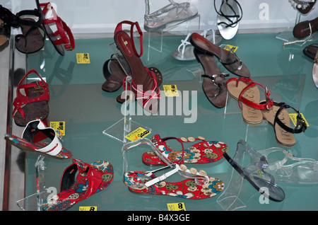 Display of shoes store. Summer sandals and handbags hanging on wall ...