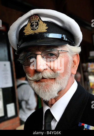 A distinguished man with a full beard and glasses, dressed in a ...