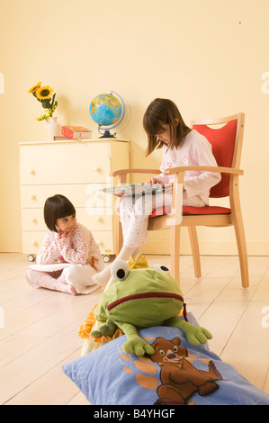little girls reading a book, pyjama Stock Photo - Alamy