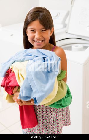 Young hispanic girl doing laundry holding socks pointing finger up with ...