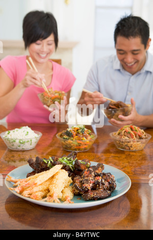 Young Asian woman enjoying healthy breakfast while using laptop ...