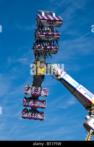 High speed thrilling carnival ride on brilliant blue sky background ...