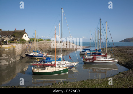 Porlock Weir, North Devon, UK. Boats at low tide and thatched cottages ...