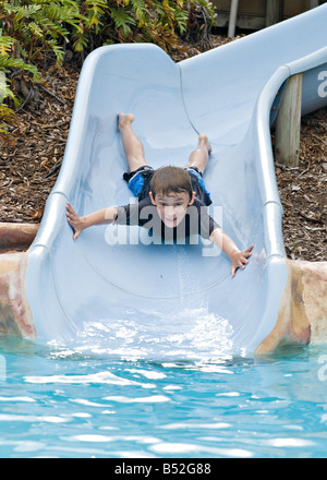 Boy swim water slide fun laugh thrill sport recreation wet pool tube ...