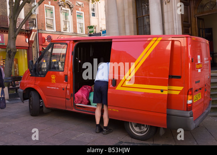 A Royal Mail postman getting mail from his van in Norwich , Norfolk ...