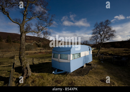 old fashioned blue caravan in a field Stock Photo - Alamy
