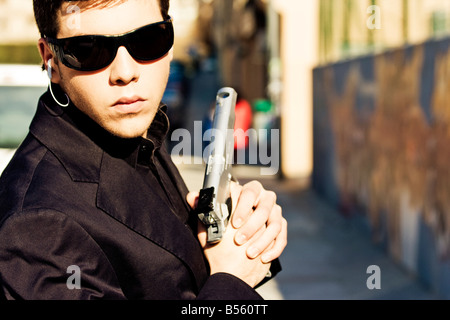 Male model performing secret agent with gun Stock Photo - Alamy