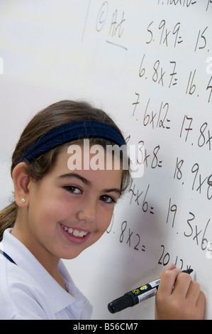 junior schoolgirl 7-10 years writing on whiteboard arithmetic maths ...