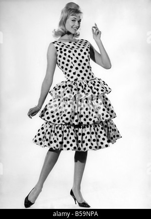 Model Jo Waring wearing a polka dot patterned top and holding a beach ...