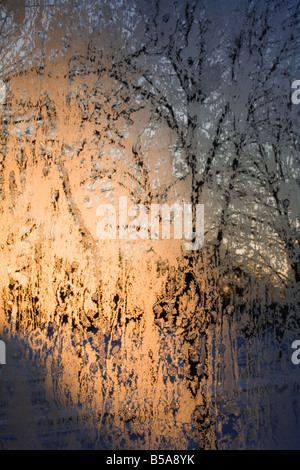 Frosted window with snow outside with sunrise background Stock Photo ...
