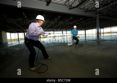 Two male construction workers fighting with tools and looking at each ...