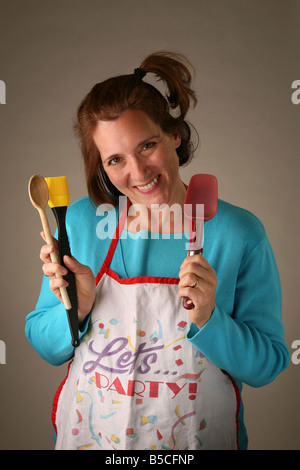 MODEL RELEASED. Smiling woman with protective gloves holding cleaning ...