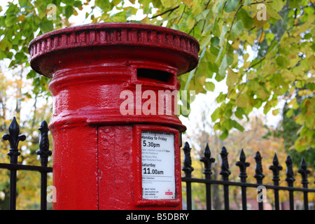 A red Royal Mail pillar box next to a yellow grit salt bin in England ...