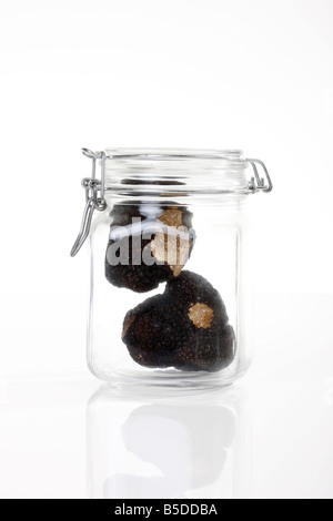 Fresh black and white truffles with jars of truffle butter and ...