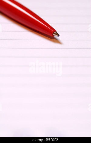 Red biro pen on lined paper close up Stock Photo - Alamy
