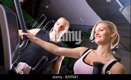 trainer with young woman on Stairmaster Stock Photo - Alamy