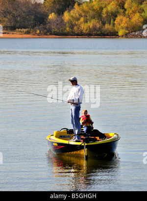 Family fishes for bass from a boat at sunset on Lake Okeechobe, Florida ...