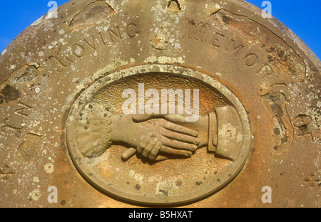 Gravestone under blue sky with carved male hand reaching out and ...