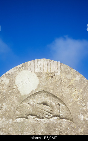 Gravestone under blue sky with carved male hand reaching out and ...