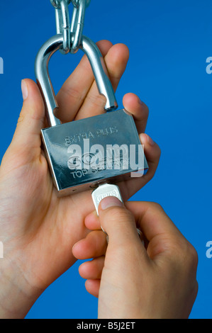 Hands securing a strong padlock with key Stock Photo - Alamy