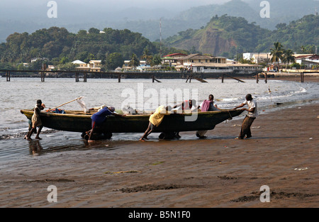 Fishermen dragging boat in at Limbé Cameroon West Africa Mount Cameroon ...