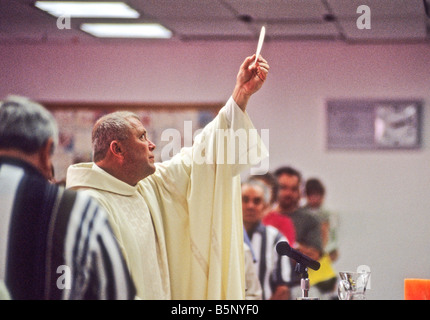 Catholic priest holds host aloft during consecration portion of ...