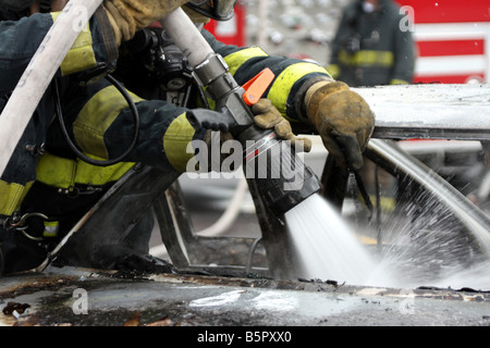 Three firefighters puting out a car fire Stock Photo - Alamy