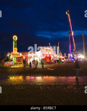 Night time photograph of various rides at a fun fair (specifically 'The ...