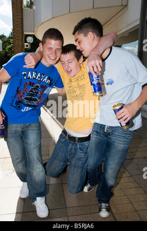 2 teenage boys helping a drunken friend who can t walk Stock Photo - Alamy