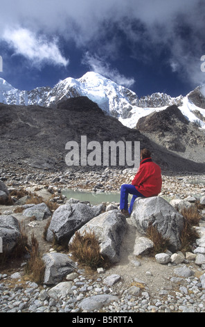 Trekker looking at view at Laguna Glaciar, Mount Illampu in background ...