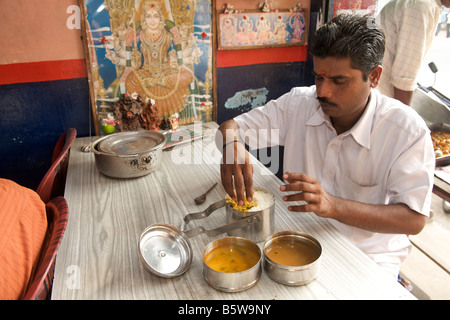 Man eating rice with sambar and vegetable curry from his tiffin box ...