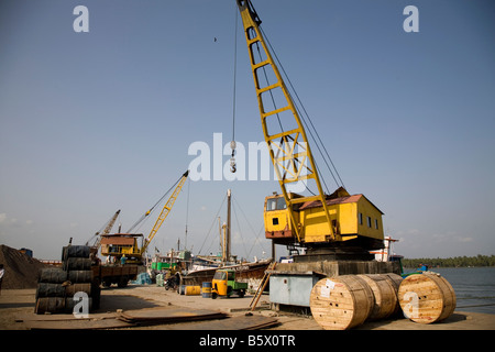 The port of Beypore in Kerala, India. Cranes and teams of workers help ...