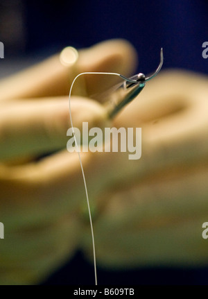 in a hospital a doctor stitches the wound on the leg of a patient Stock ...