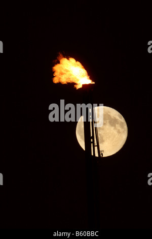 Full moon behind natural gas flame Stock Photo - Alamy