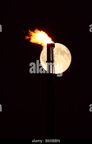 Full moon behind natural gas flame Stock Photo - Alamy