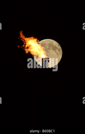 Full moon behind natural gas flame Stock Photo - Alamy