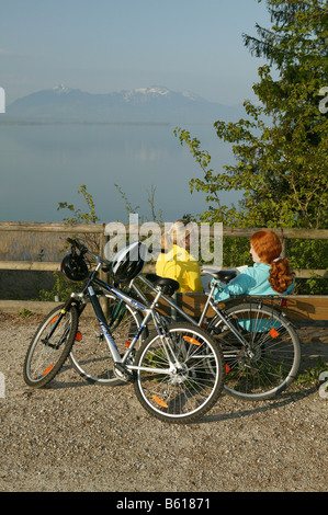 Two cyclists having a rest on a park bench on West Island, Australian ...