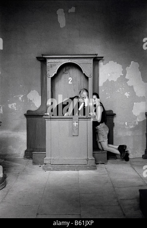 Catholic confession – a woman confessing to a Catholic priest – during ...