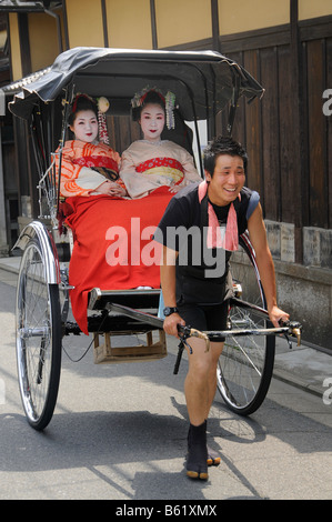 People being pulled in rickshaws sightseeing in Japan Stock Photo - Alamy