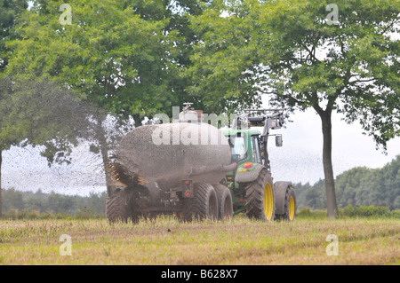 Farmer spreading manure over a harvested field Stock Photo - Alamy