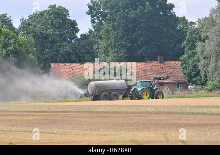Farmer spreading manure over a harvested field Stock Photo - Alamy
