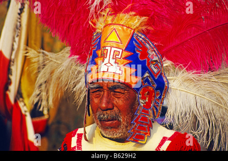 A Mexican man, wearing a colorful feather mask inspired by Aztecs ...